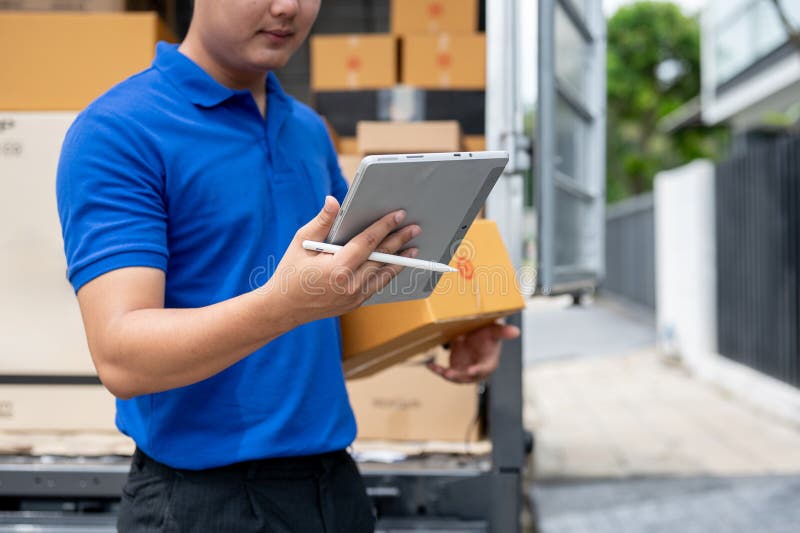 A Delivery Guy Checking the Address on His Tablet while Carrying a ...