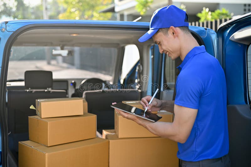 Delivery Man in Blue Uniform Checking Package on Tablet before Sending ...