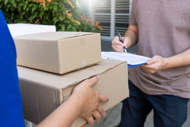 Delivery Man in Blue Uniform Handing Parcel Box for Client Signing ...