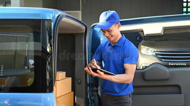 Delivery Man in Blue Uniform Using Digital Tablet Next To Open Delivery ...