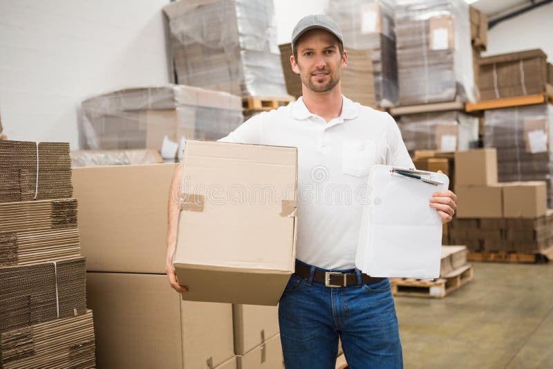 Delivery Man with Box and Clipboard in Warehouse Stock Image - Image of ...