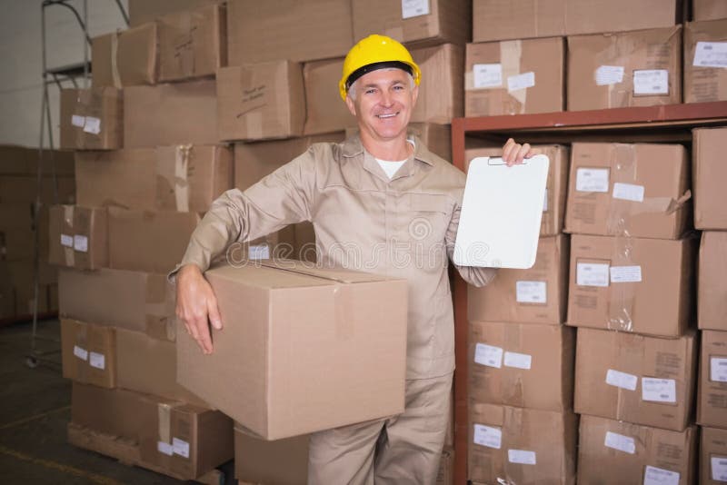 Delivery Man with Box and Clipboard in Warehouse Stock Photo - Image of ...