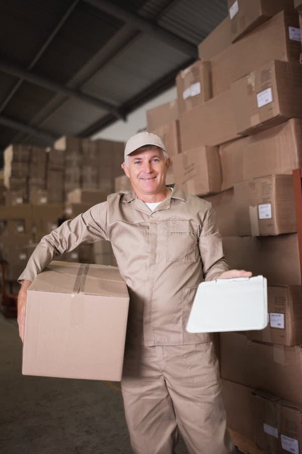 Delivery Man with Box and Clipboard in Warehouse Stock Photo - Image of ...