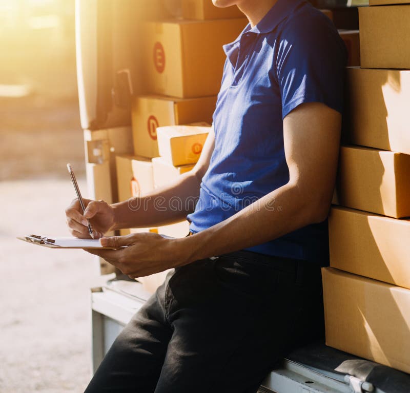 Delivery Man with Cardboard Box Checking Document List in Van and ...