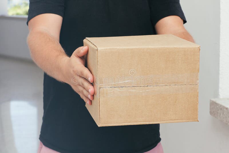 Delivery Man with Cardboard Parcel. Hand Holding the Delivery Box ...