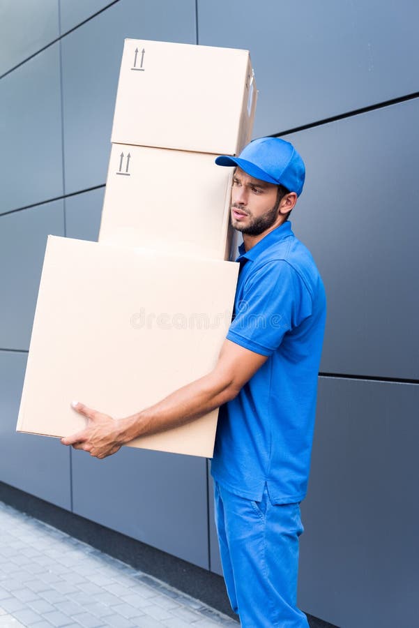 Delivery man with boxes stock photo. Image of postal - 99748982
