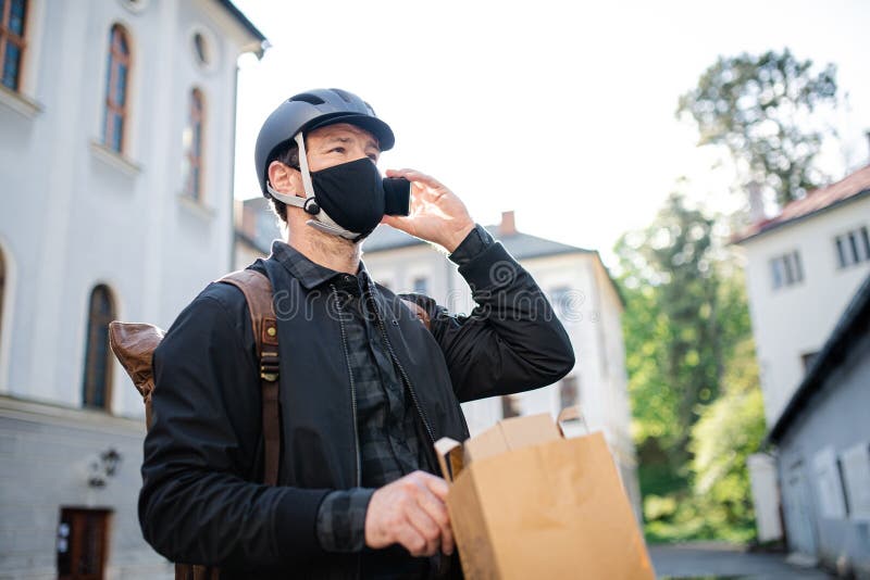 Delivery Man Courier with Face Mask and Bicycle Using Smartphone in ...