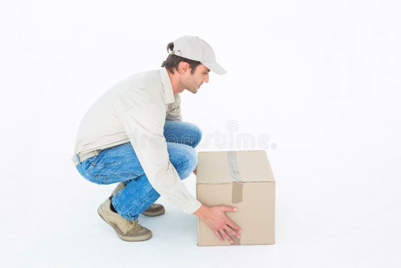 Delivery Man Crouching while Picking Cardboard Box Stock Photo - Image ...
