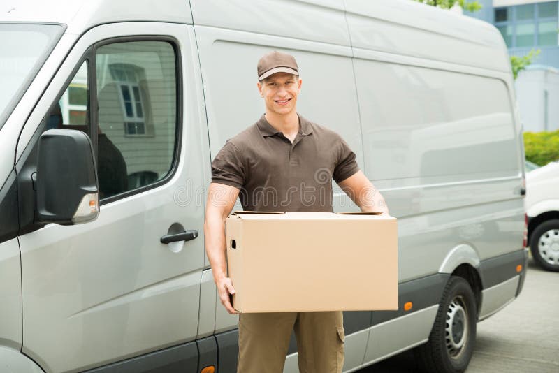 Smiling Delivery Man Standing in Front of His Van Holding a Package ...