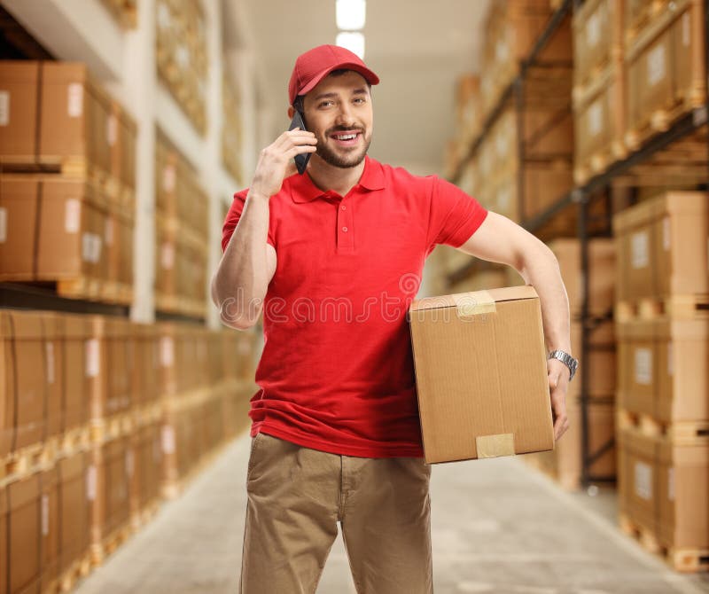 Delivery Man Holding a Package and Talking on the Phone in a Storage ...