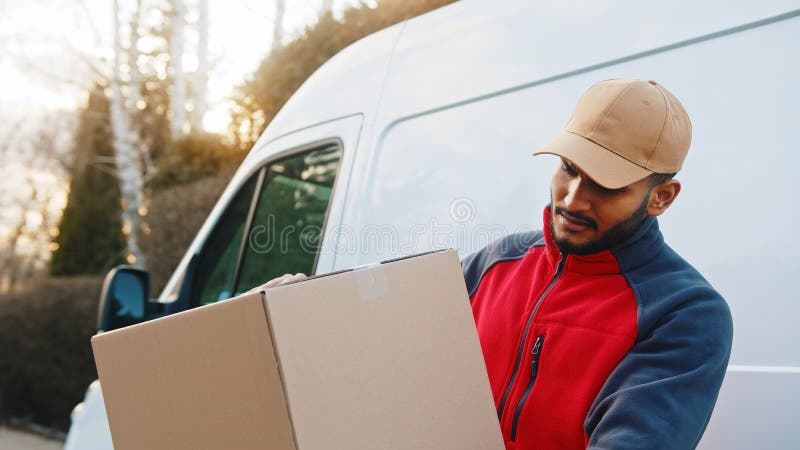 Delivery Man Holding Parcel in Front of Transportation Van Stock Image ...