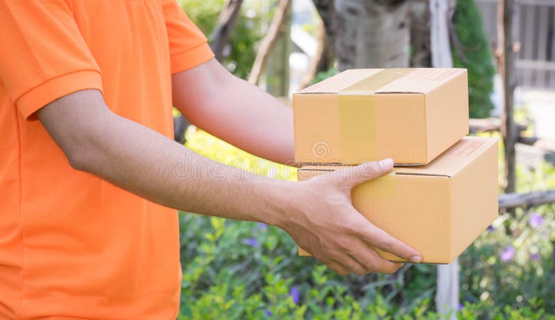 Delivery Man in Orange Handing Packages Stock Image - Image of package ...