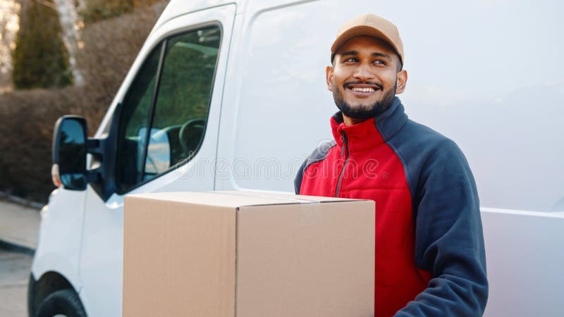 Delivery Man Smiling while Holding Parcel in Front of Transportation ...