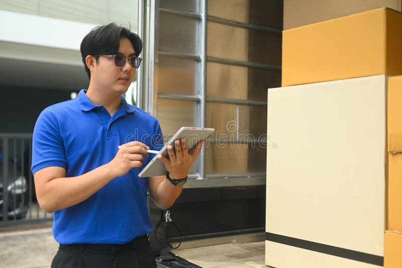 Delivery Man Standing Near the Back of a Truck and Using Digital Tablet ...