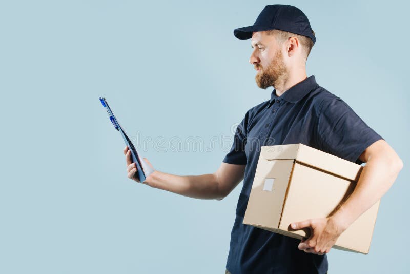 Delivery Man in Uniform is Checking His Orders List while Holding Box ...