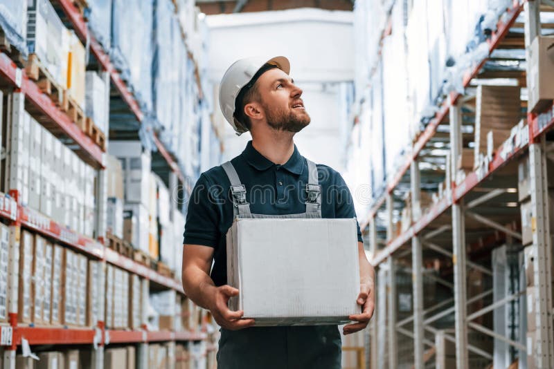 With Delivery Package in Hands. Employee in Uniform is Working in the ...