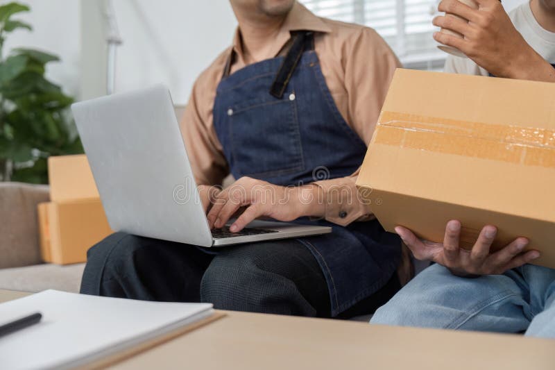 Delivery Professional Typing on a Laptop while Another Holds a Package ...