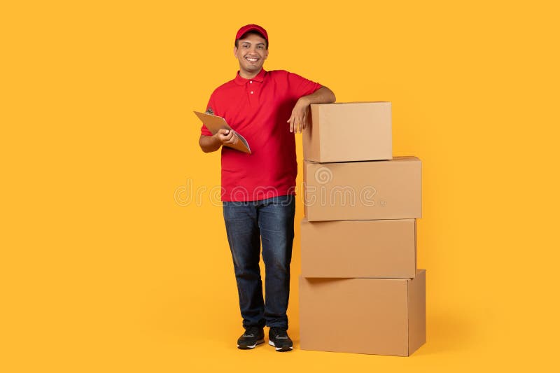 Delivery Worker Leaning on Stacked Boxes in Yellow Studio Setting Stock ...