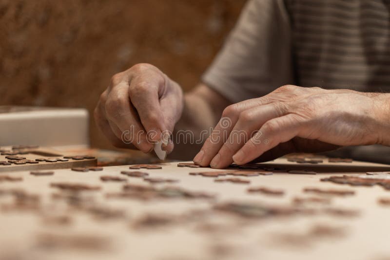 Dementia Prevention. Elderly Man Hands Doing Jigsaw Puzzle at Home ...