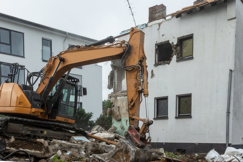 Demolition of a Building. an Excavator Breaks an Old House Stock Photo ...