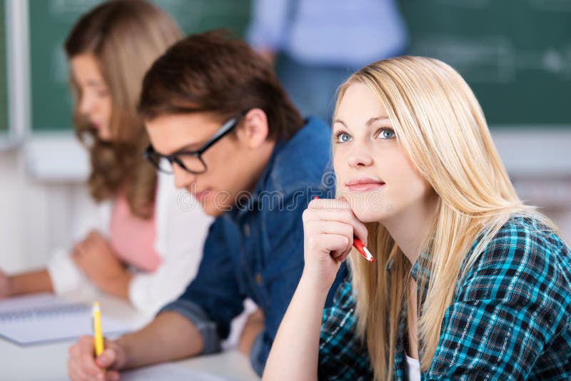 Denkende Studentin Sitting with Classmates Stockfoto - Bild von ...