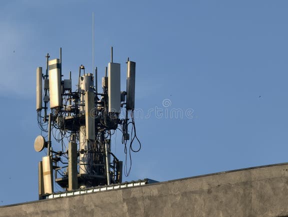 A Complex Cell Tower on a Rooftop Against a Clear Blue Sky, Showing ...