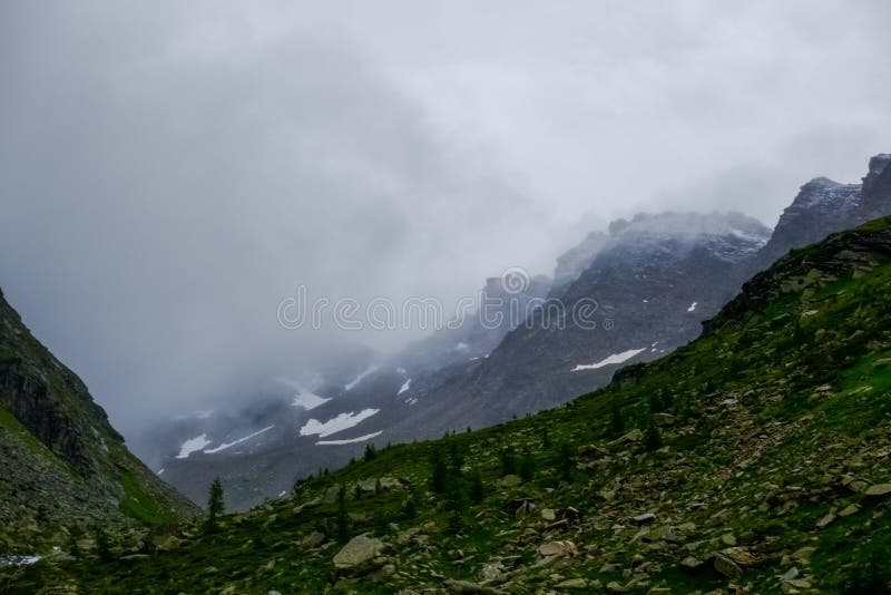 Dense Fog and Snow while Hiking in the Mountains in the Summer Stock ...