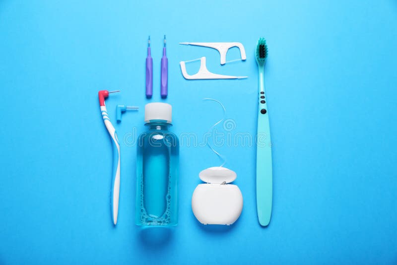 Dental Floss and Different Teeth Care Products on Light Blue Background ...