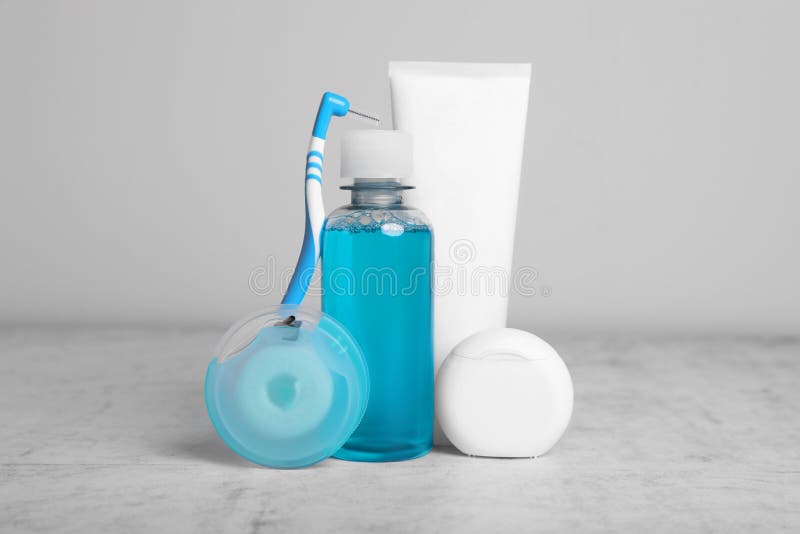 Dental Floss and Different Teeth Care Products on Light Grey Textured ...
