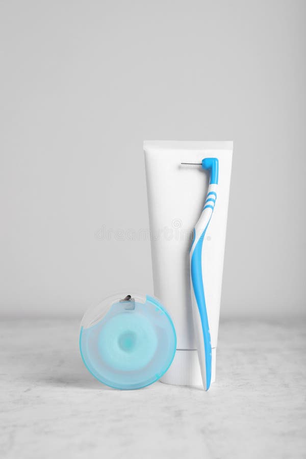 Dental Floss and Different Teeth Care Products on Light Grey Textured ...