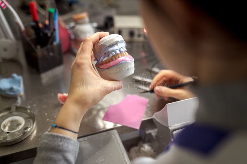 Dental Technician Makes a Denture for the Patient. Prosthetics and Production of Model Teeth in ...