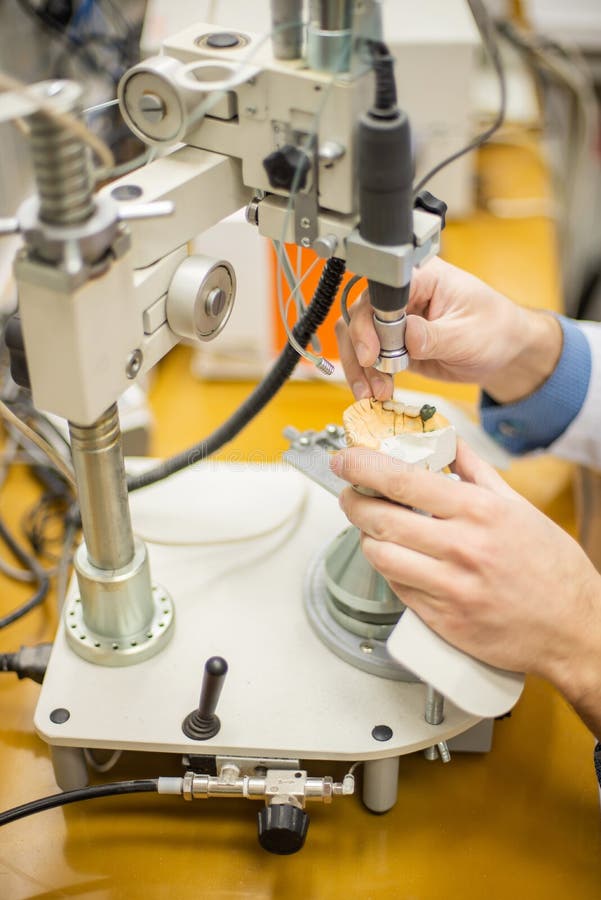 A Dental Technician Makes Partial Dentures on a Mechanized Machine. the ...
