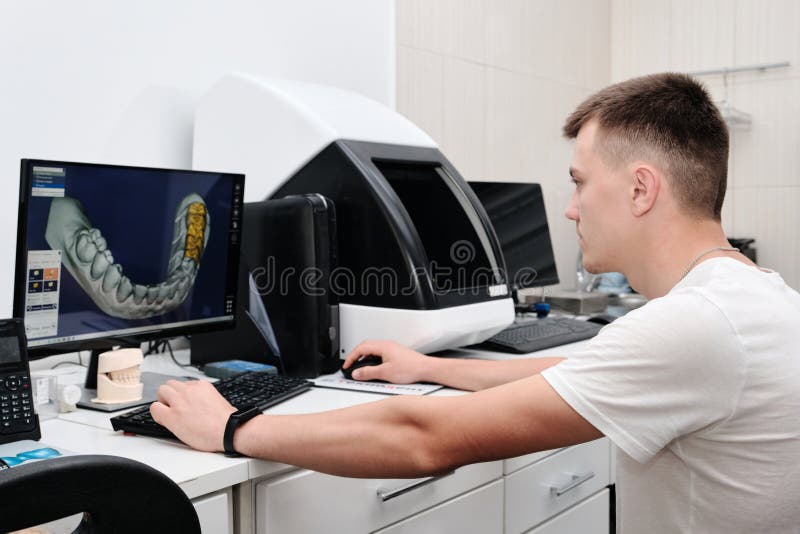 Dental Technician Working with a Computer in a Laboratory. 3D Modeling ...
