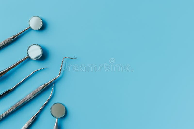 Dental Tools and a Model of Teeth Displayed on a Light Blue Background ...