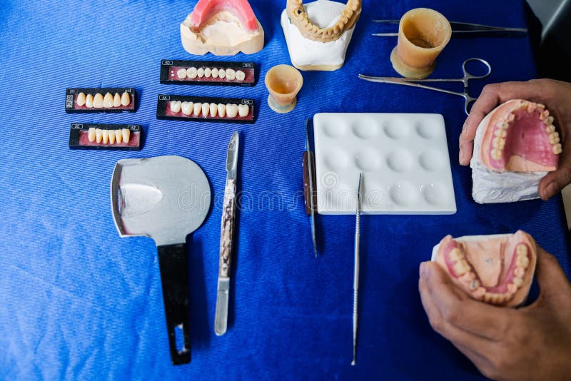Dental Tools and Prosthetic Teeth Molds on a Blue Workspace Stock Photo ...