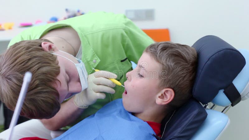 Dentist Checks Teeth of Boy by Dental Mirror in Stock Footage - Video ...