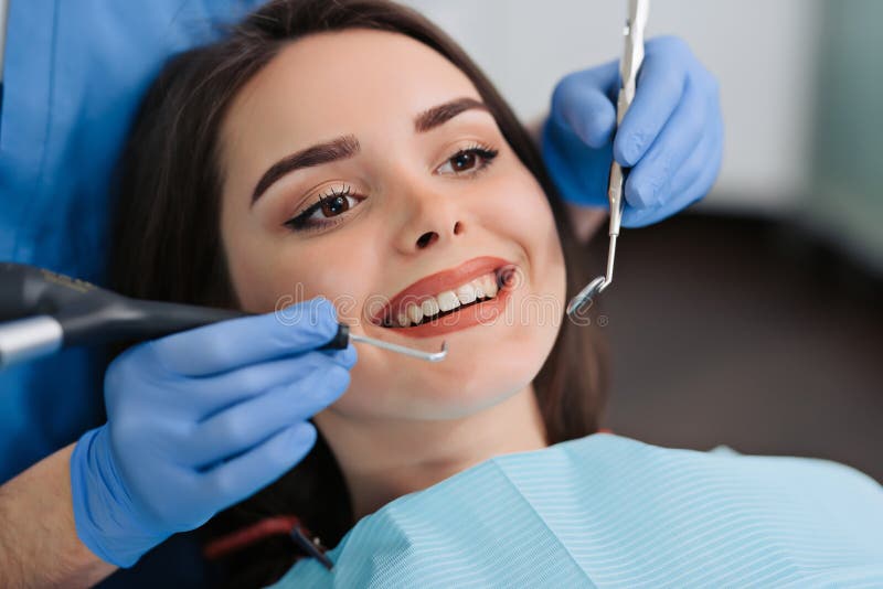 Dentist Curing a Female Patient Stock Photo - Image of female, young ...
