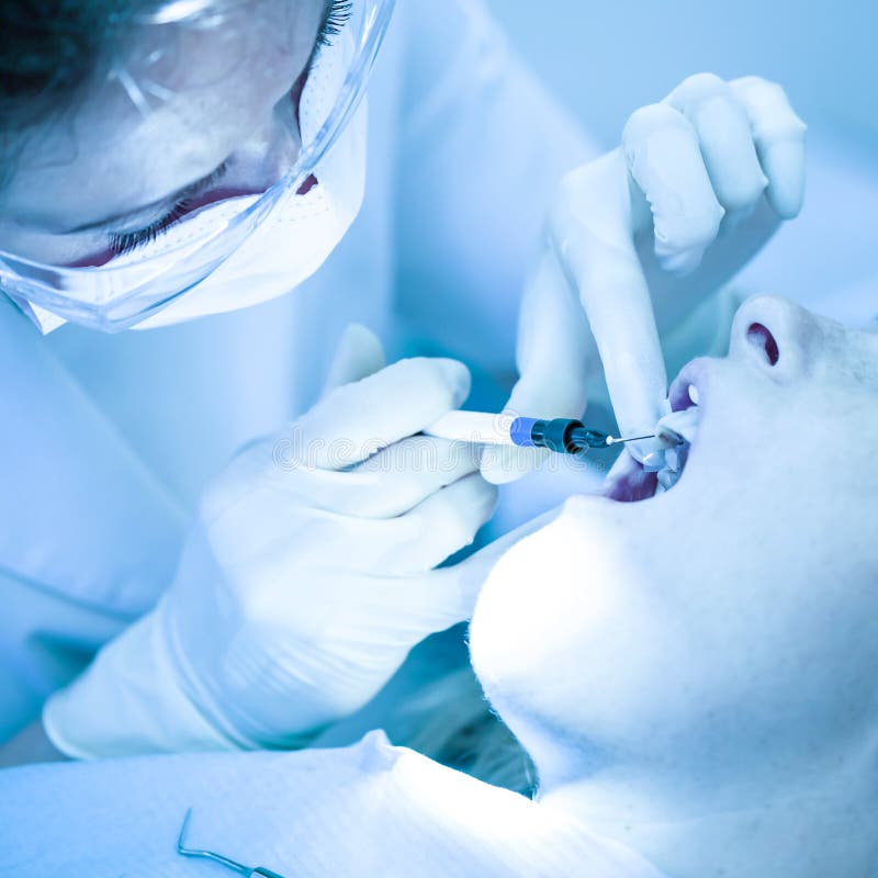 Dentist Curing a Female Patient Stock Photo - Image of orthodontic ...