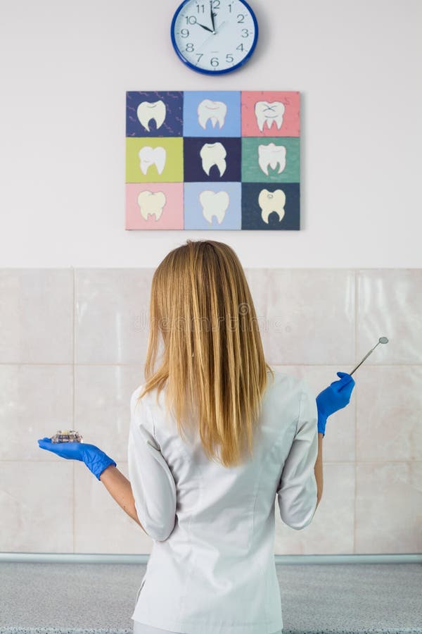 A Dentist in a Dental Clinic. with His Back To the Camera. Hold Stock ...