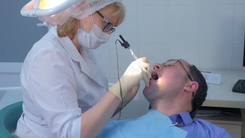 Dentist Examining Patient Gums with Probe Using Method of Computer ...