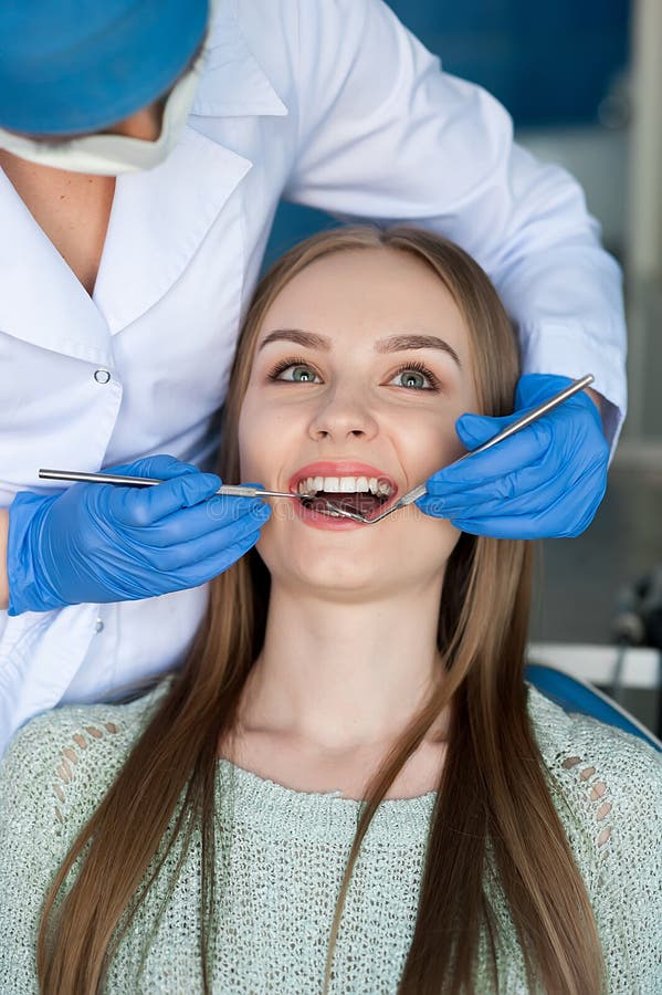 Dentist Examining a Patient`s Teeth in the Dentist. Stock Image - Image ... Dentist Examining a Patient`s Teeth in the Dentist. Stock Image - Image ...