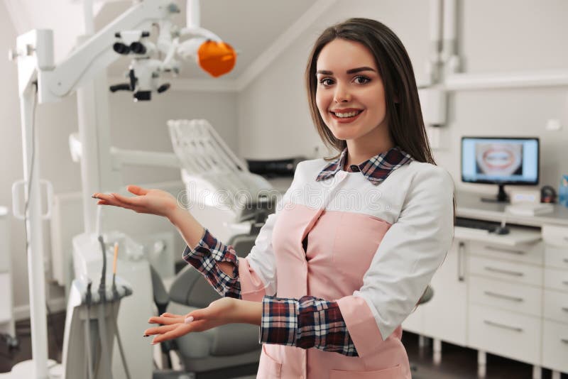 Dentist Female In Uniform Showing Her Dentist`s Office Stock Image