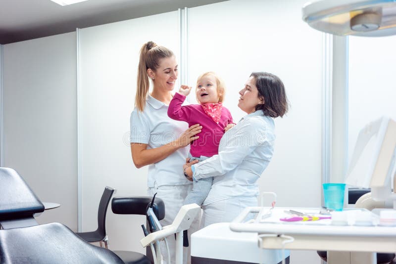 Dentist and Her Assistant with Child in the Office Stock Photo - Image ...