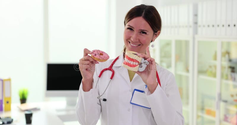 Dentist is Holding Plastic Jaws and Sweet Pink Donut Stock Video ...