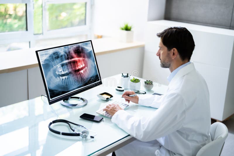 Dentist Looking at Teeth X-ray on Computer Stock Photo - Image of ...