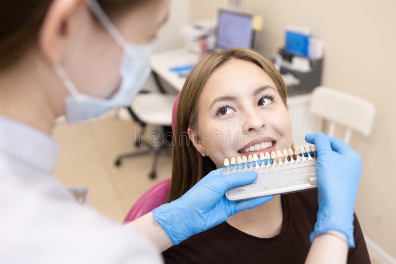 The Dentist Selects the Tone of the Patient S White Teeth with a Pallet ...