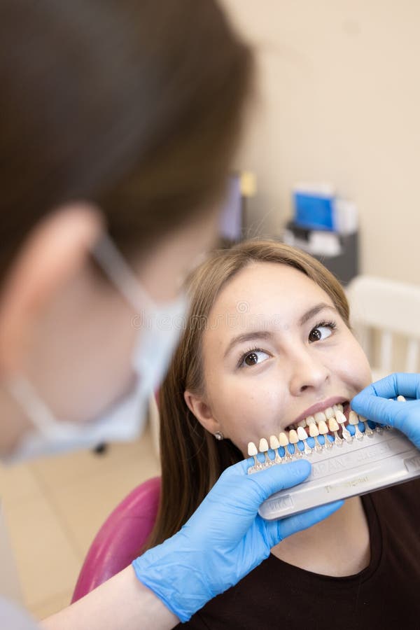 The Dentist Selects the Tone of the Patient S White Teeth with a Pallet ...