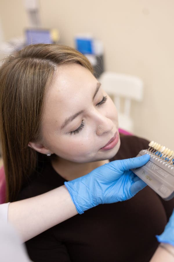 The Dentist Selects the Tone of the Patient S White Teeth with a Pallet ...