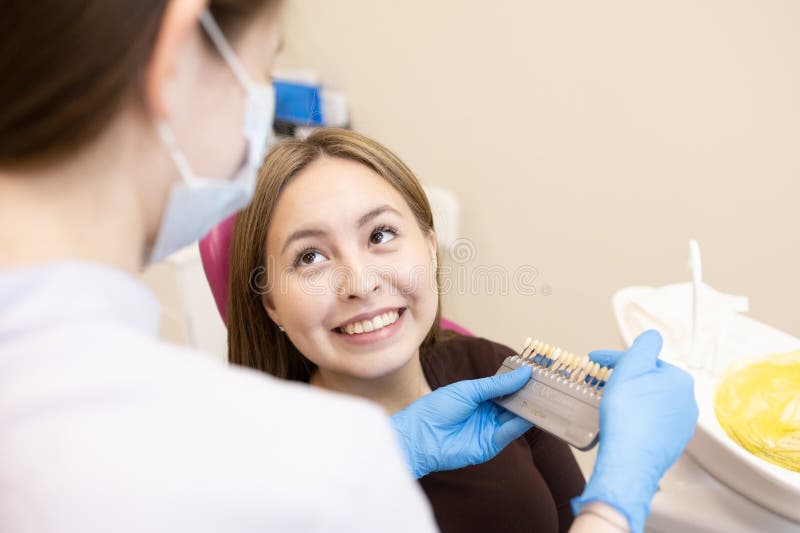 The Dentist Selects the Tone of the Patient S White Teeth with a Pallet ...