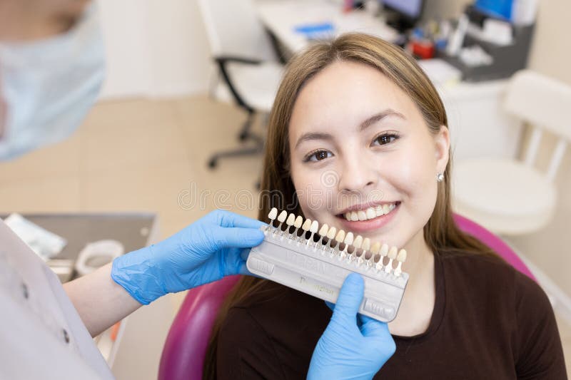 The Dentist Selects the Tone of the Patient S White Teeth with a Pallet ...